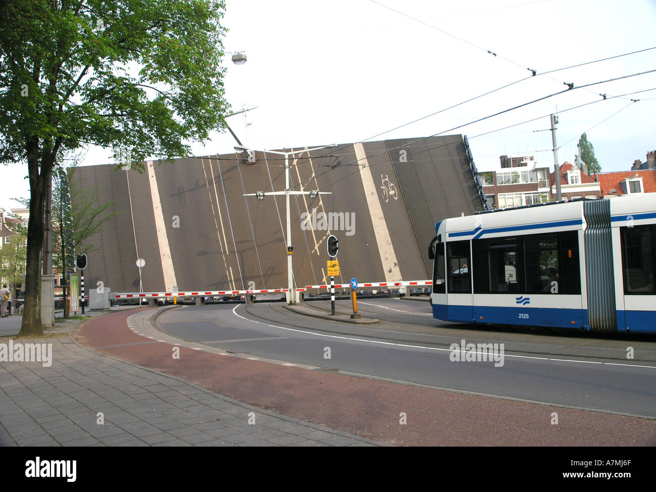 Raised road canal bridge amsterdam with a tram stopped while it is ...