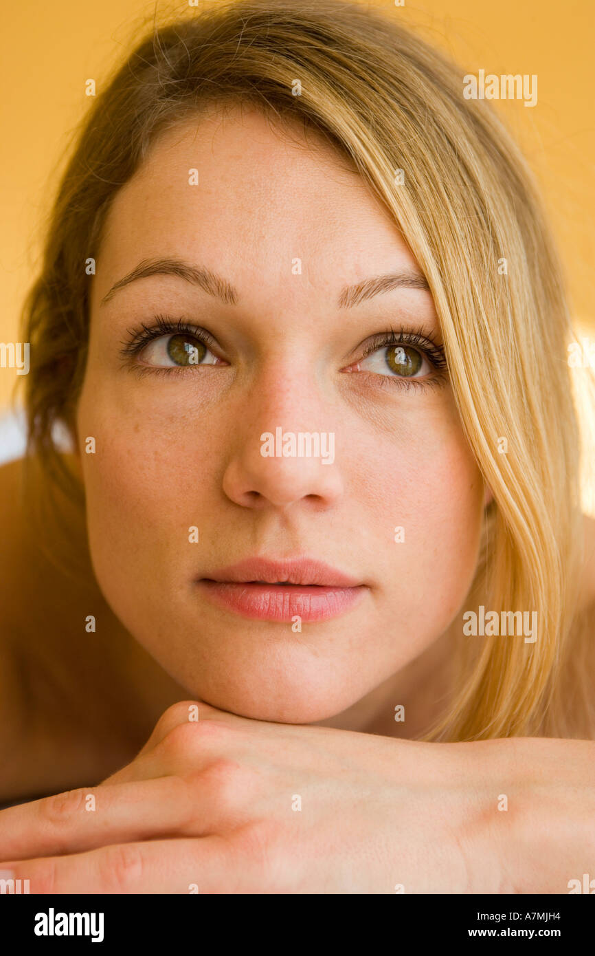 Young woman resting chin on hand Stock Photo - Alamy