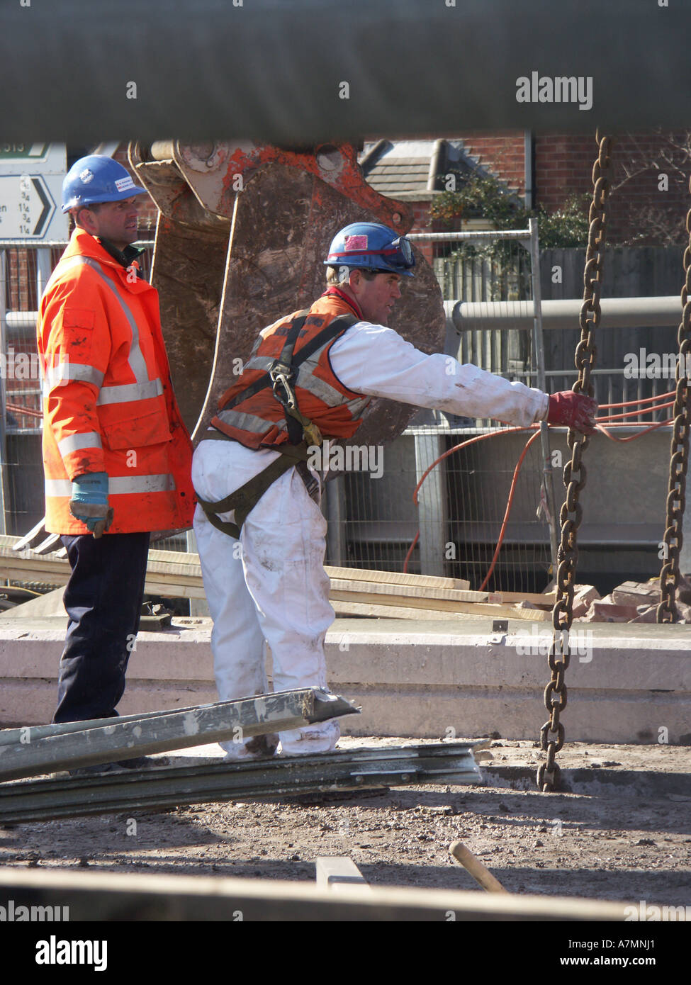 Two construction workers on site dressed in correct clothing for the ...