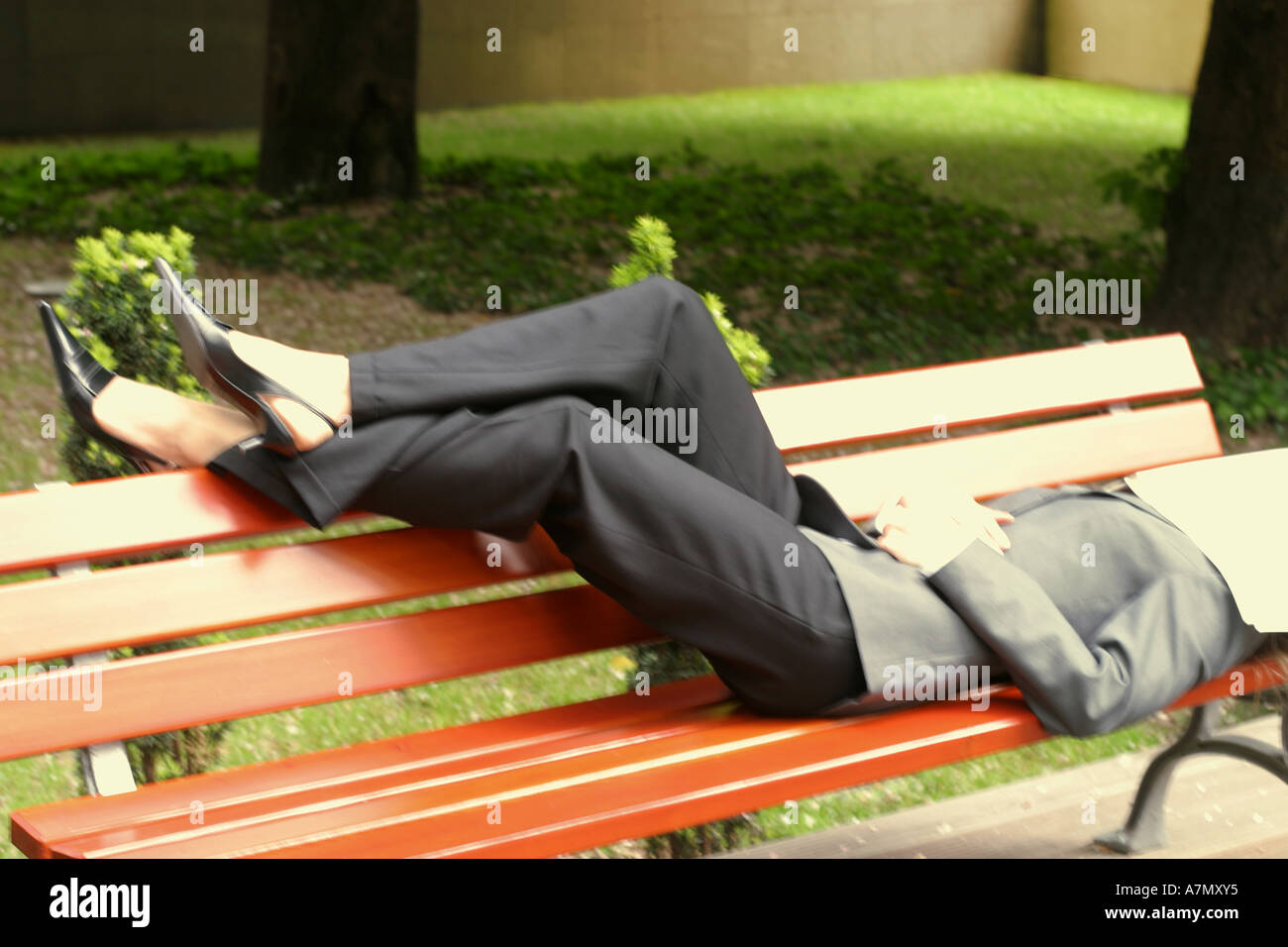 Young woman lying on bench Stock Photo - Alamy