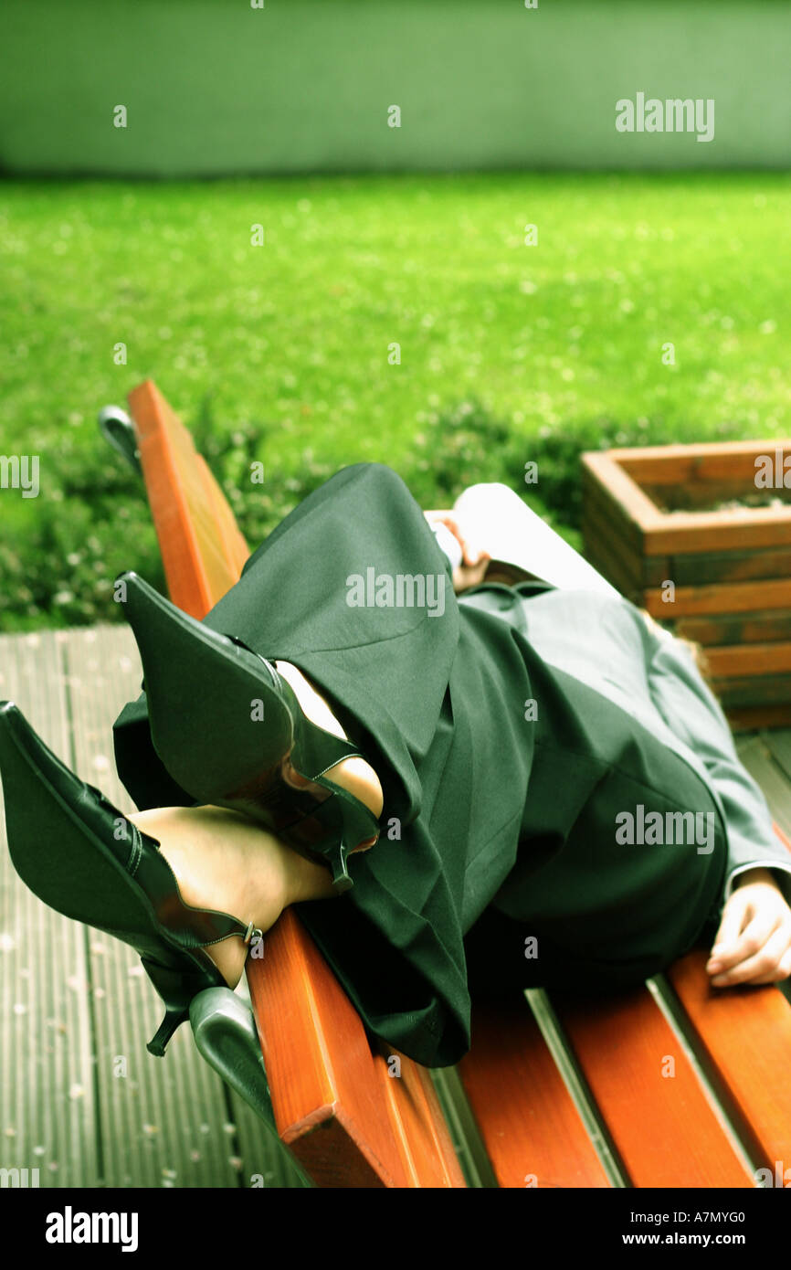 Young woman lying on a bench Stock Photo - Alamy