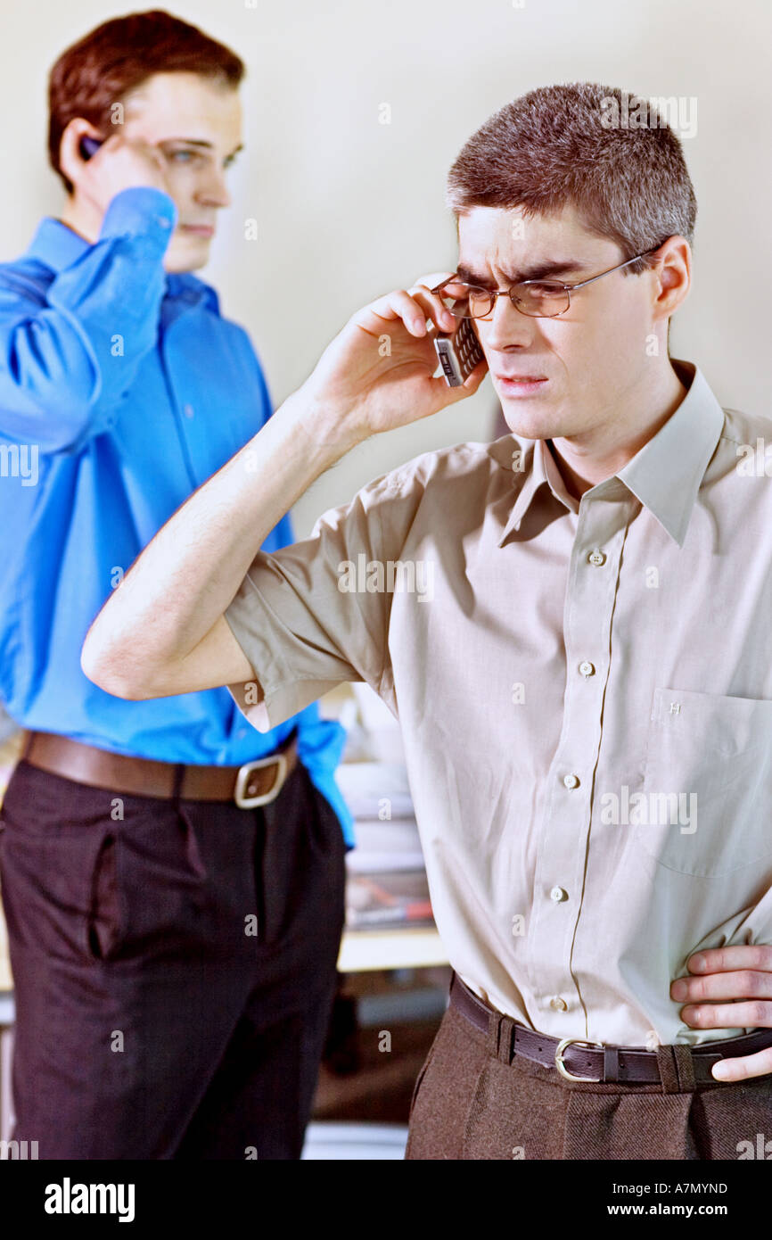 Two men talking on the phones in the office Stock Photo - Alamy