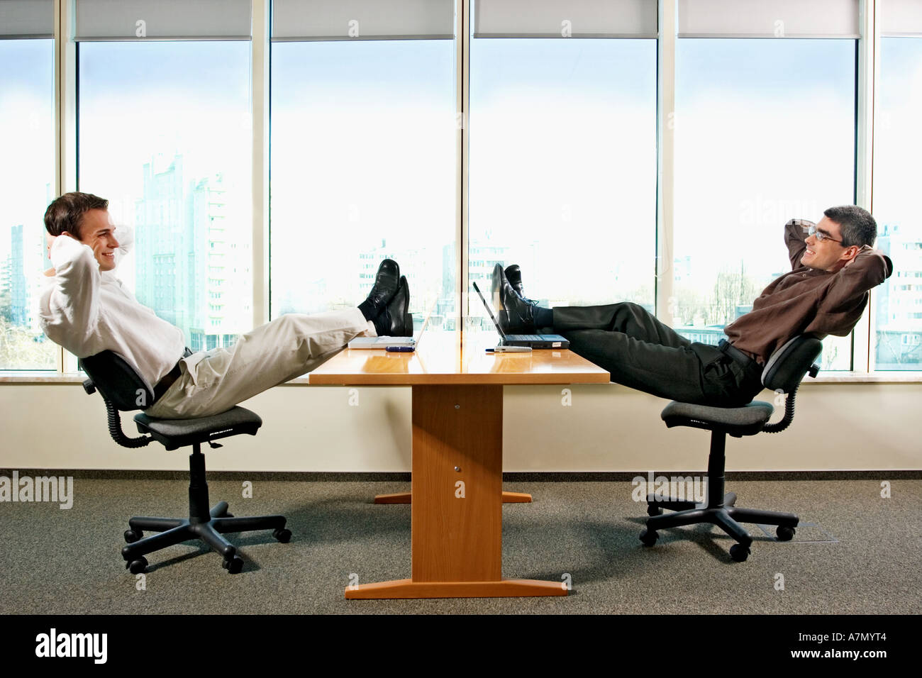 Two young men sitting in the office Stock Photo - Alamy