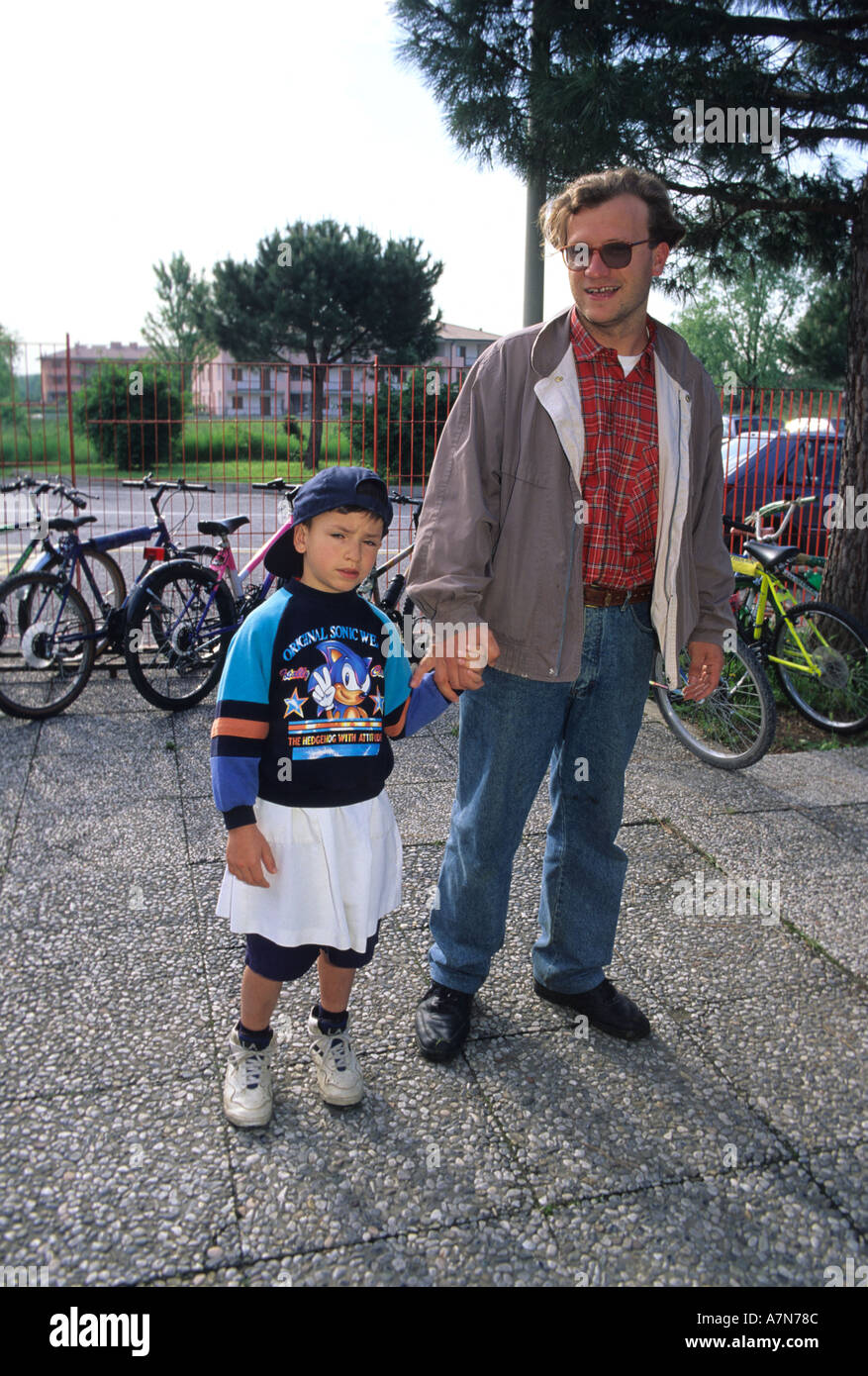 Italian father and son holding hands enroute to school The white apron ...