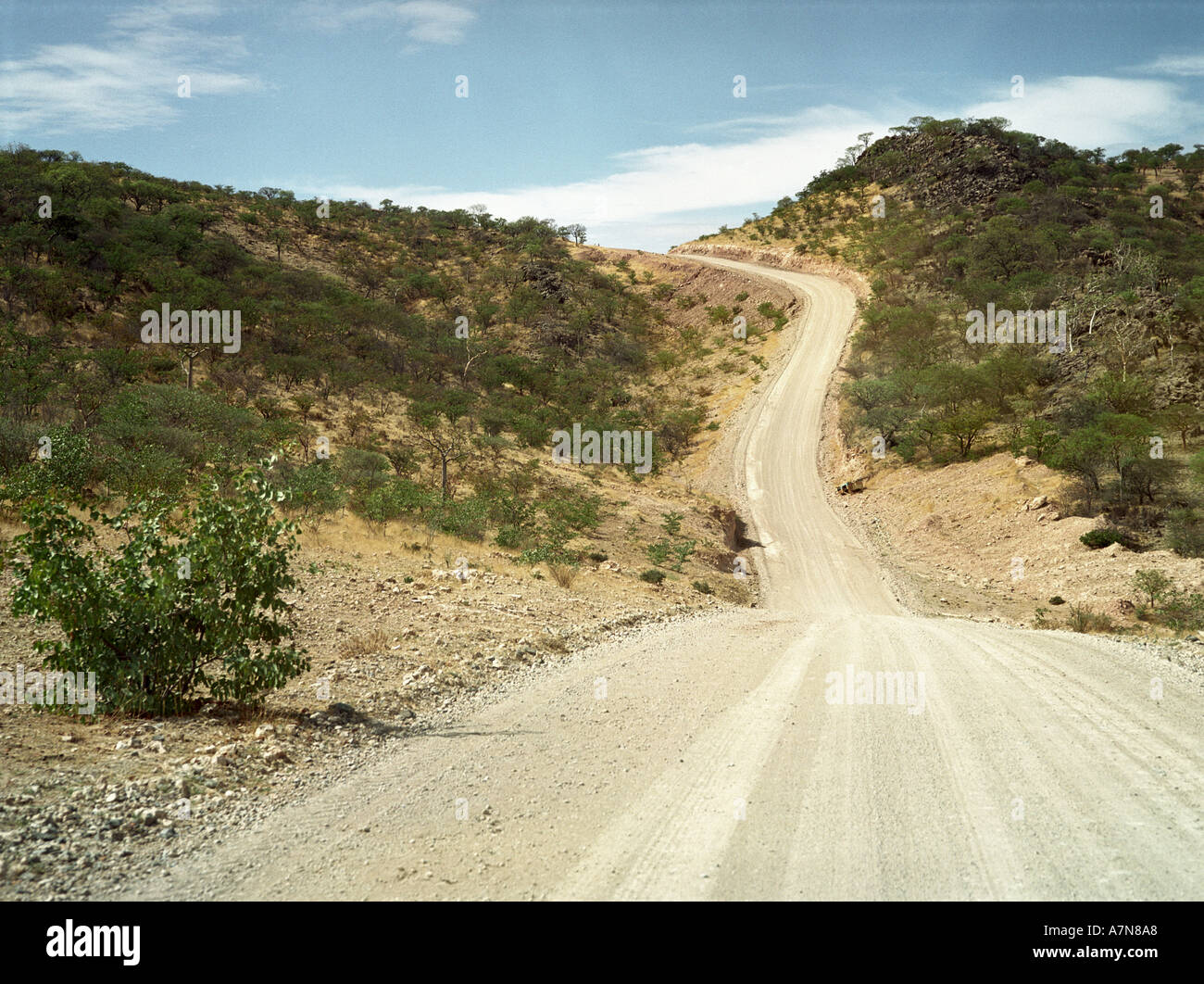 a dusty african road leading through the mountains of the west coast of ...