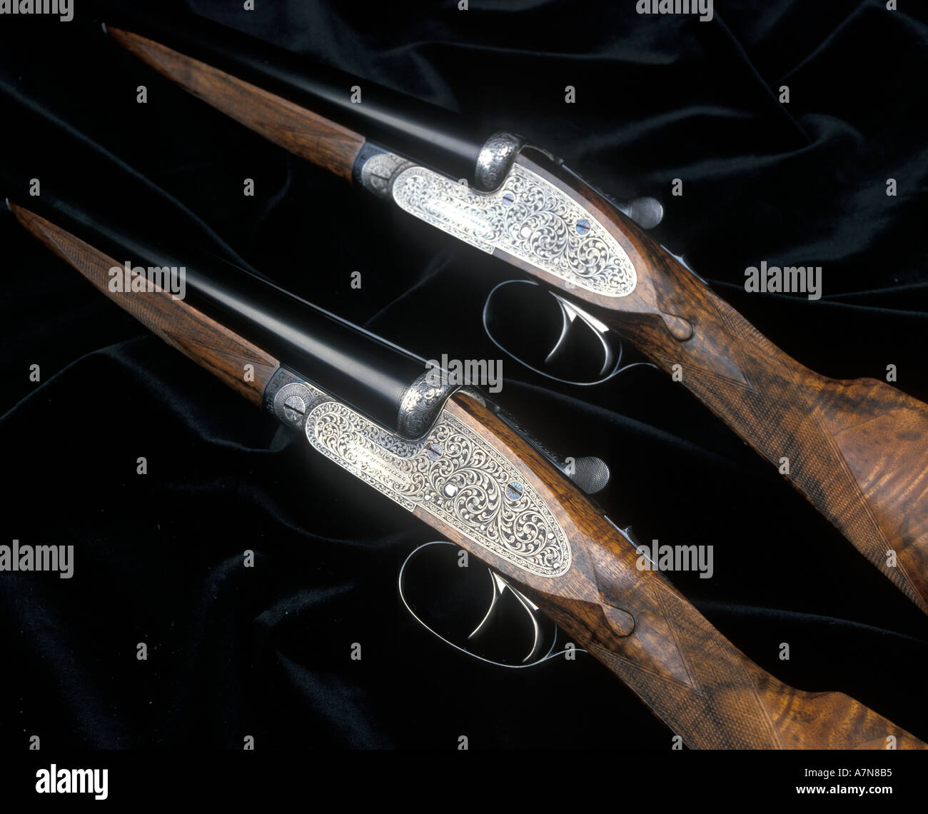 a close up detail photograph of a pair of twelve bore shotguns in a ...