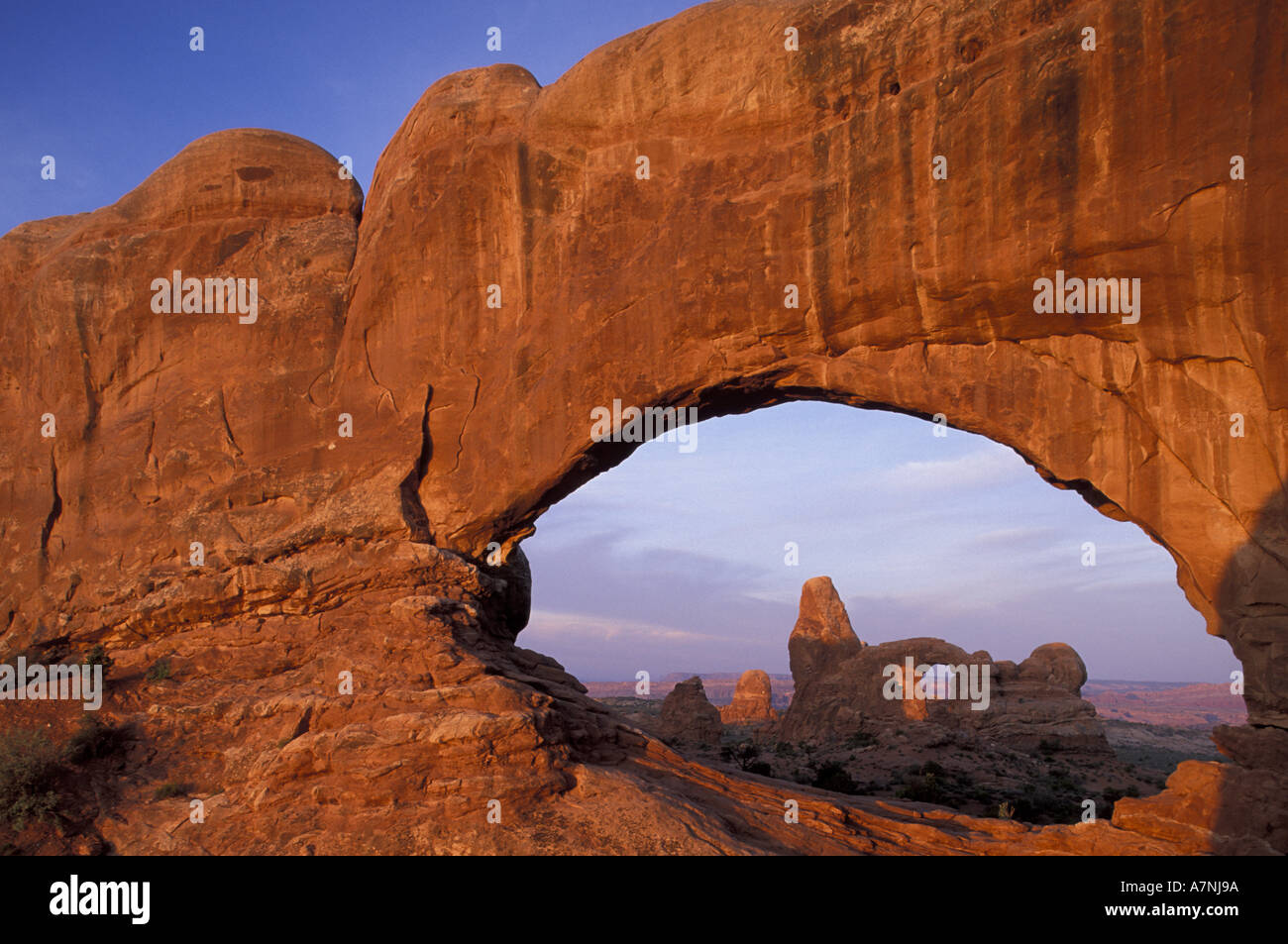 NA, Utah, Arches National Park. Double Arch frames Turret Arch at first ...