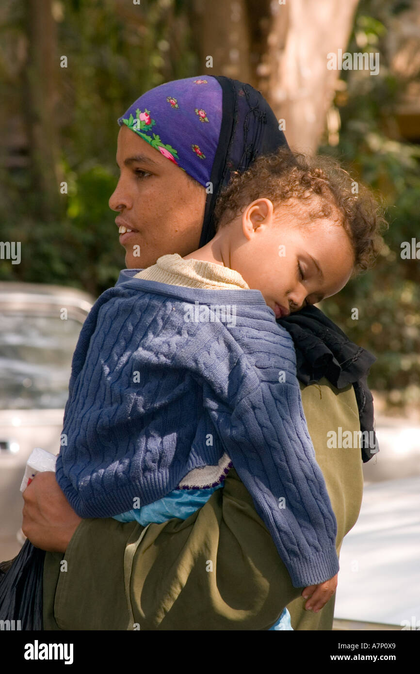 Egyptian woman carrying young sleeping child Stock Photo - Alamy
