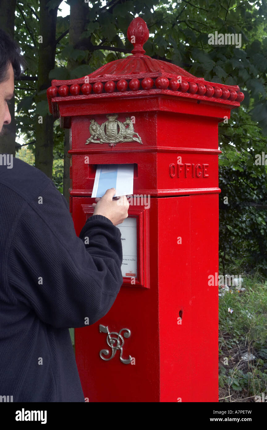 Man posting a letter in Victorian post box Stock Photo - Alamy