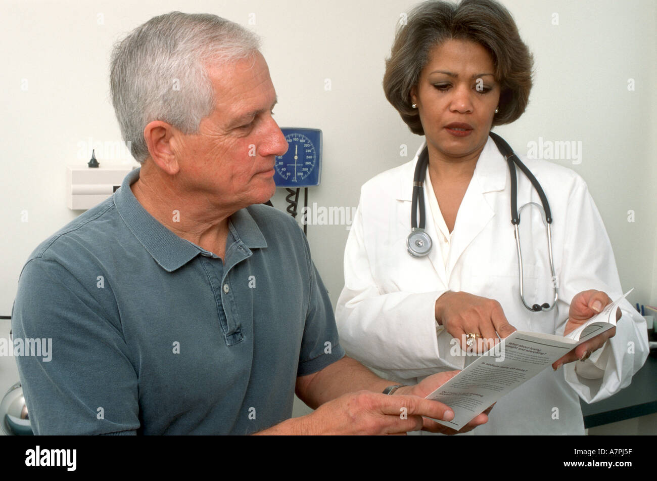 A doctor offers medical advice to a patient during an office visit ...
