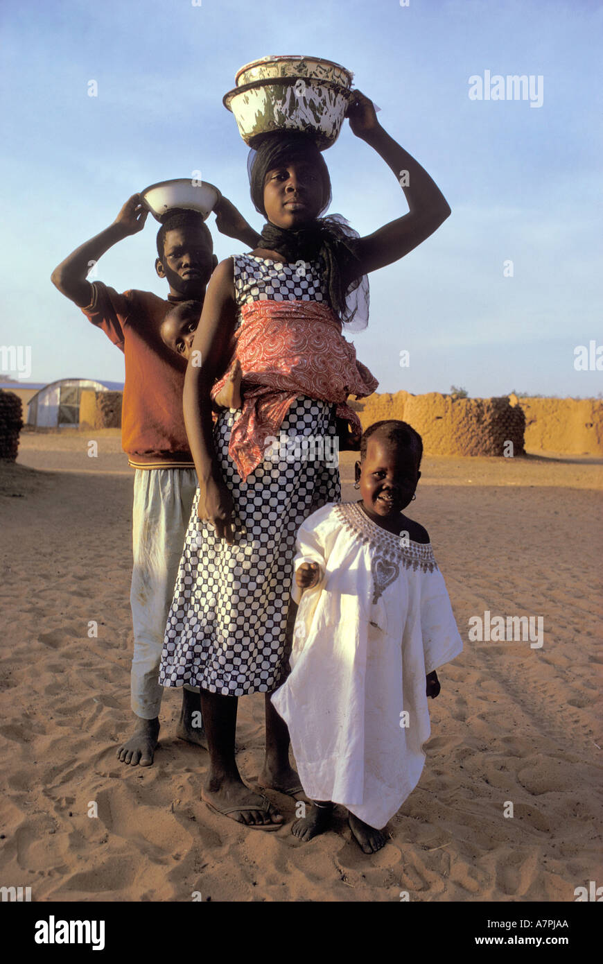 Sad impoverished family carrying bowls of food in a remote ancient ...