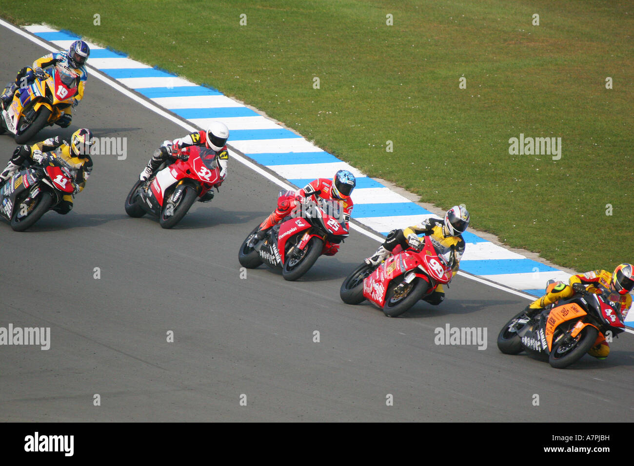 Racing motorcycles and riders in competition at high speed at ...