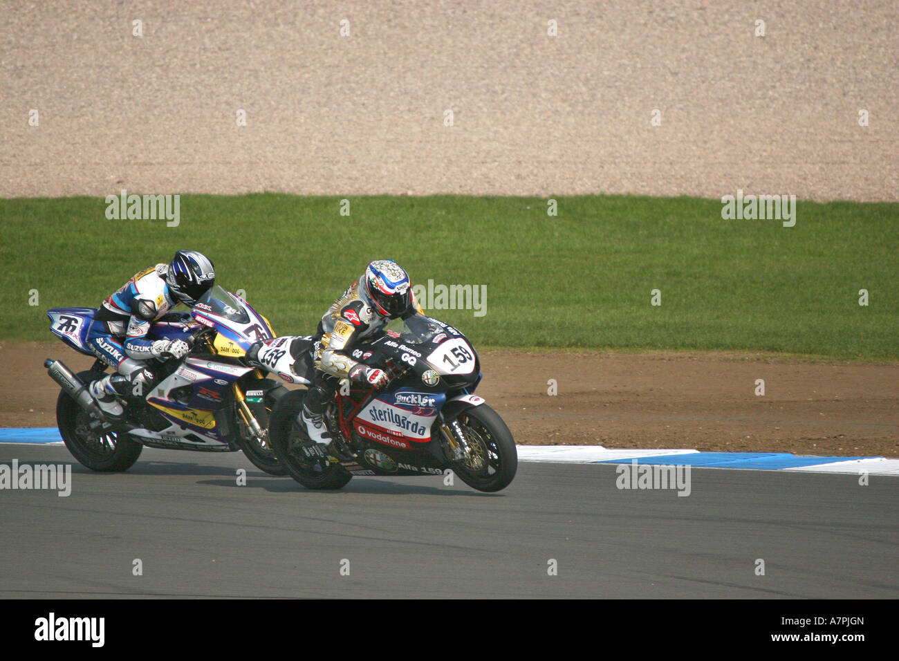 Racing motorcycles and riders in competition at high speed at ...