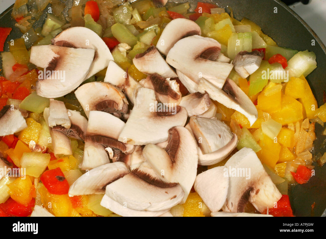 Sliced mushrooms cooking in pan with prepared vegetables Stock Photo ...