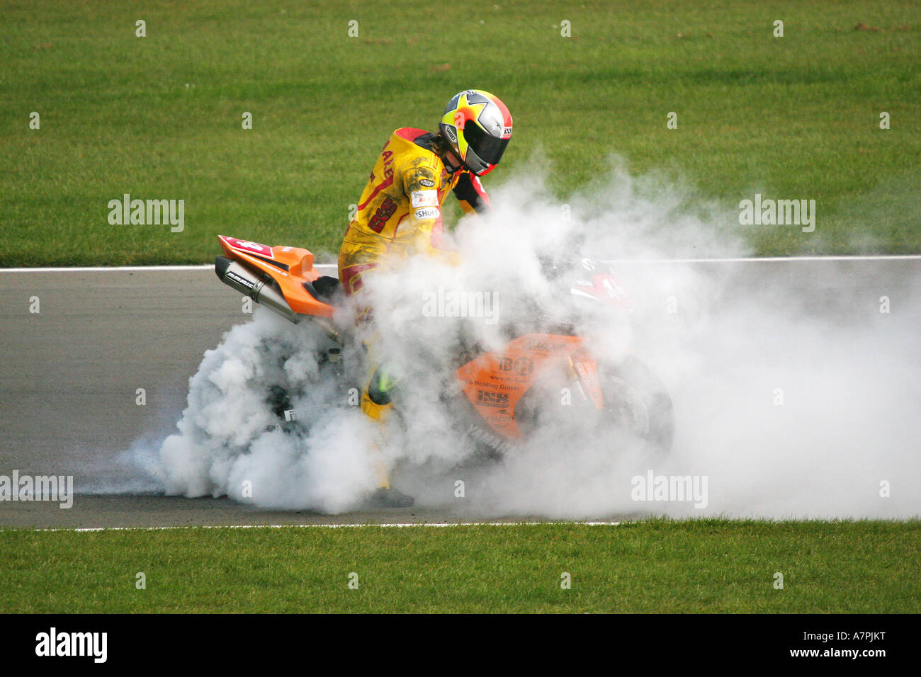 Rider smoking his bike rear tyre after a championship race Stock Photo ...
