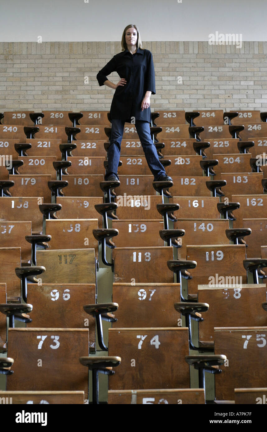 A female student standing on the chairs in a lecture hall Stock Photo ...