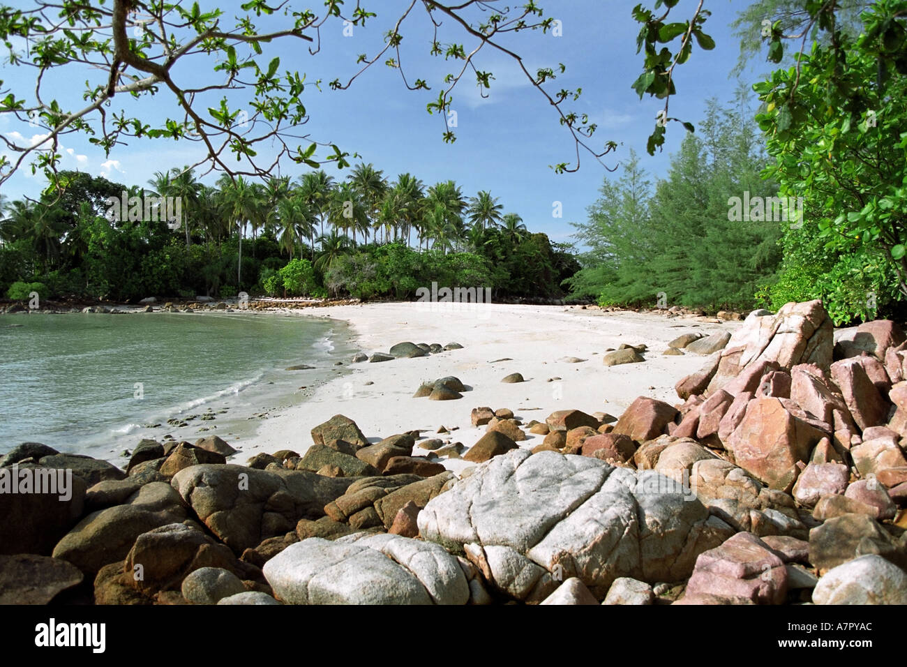 Secluded sandy beach with granite boulders at one side. Bintan island ...