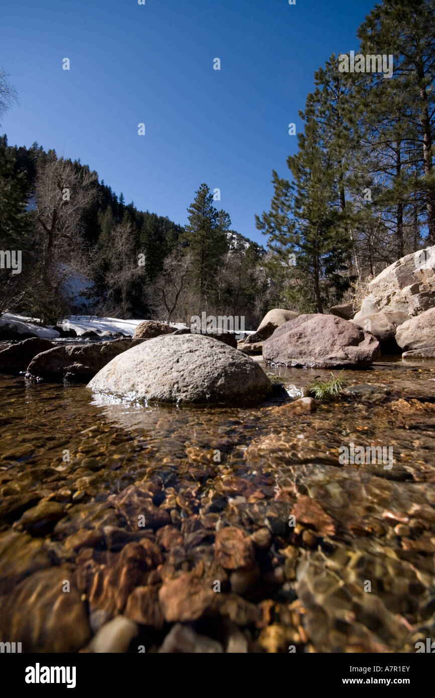Boulder in river with wide angle lens and low view point. Blue sky and ...