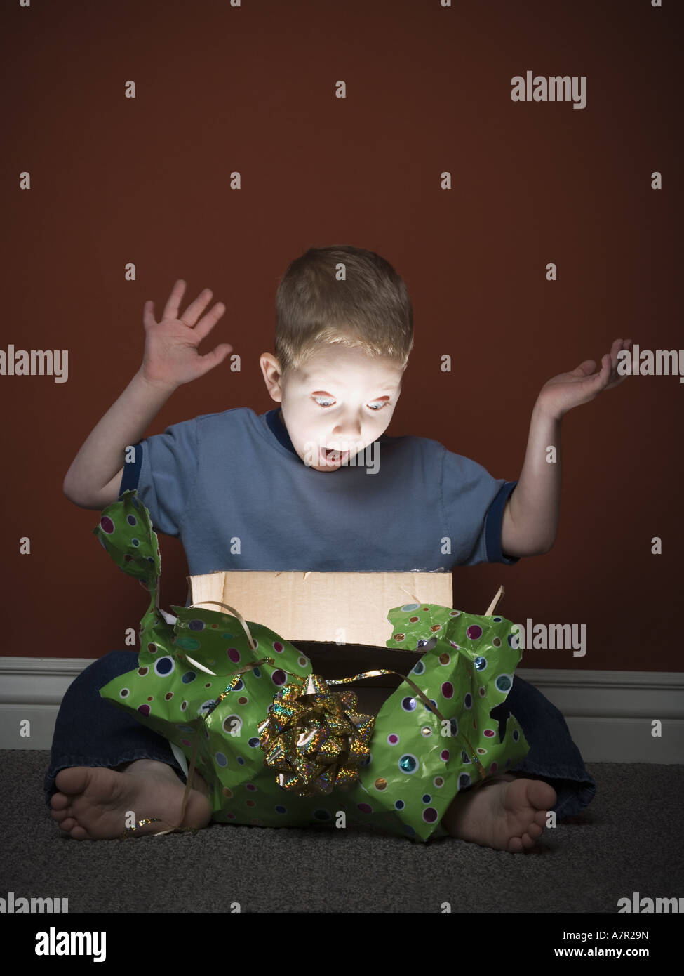 Young boy opening present Stock Photo - Alamy
