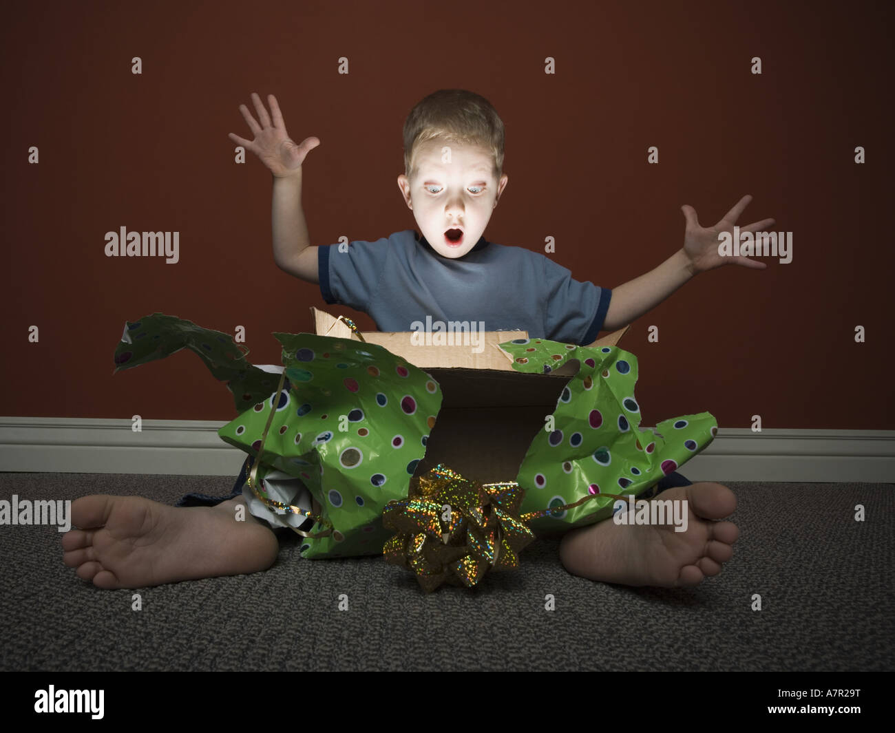 Young boy opening present Stock Photo - Alamy