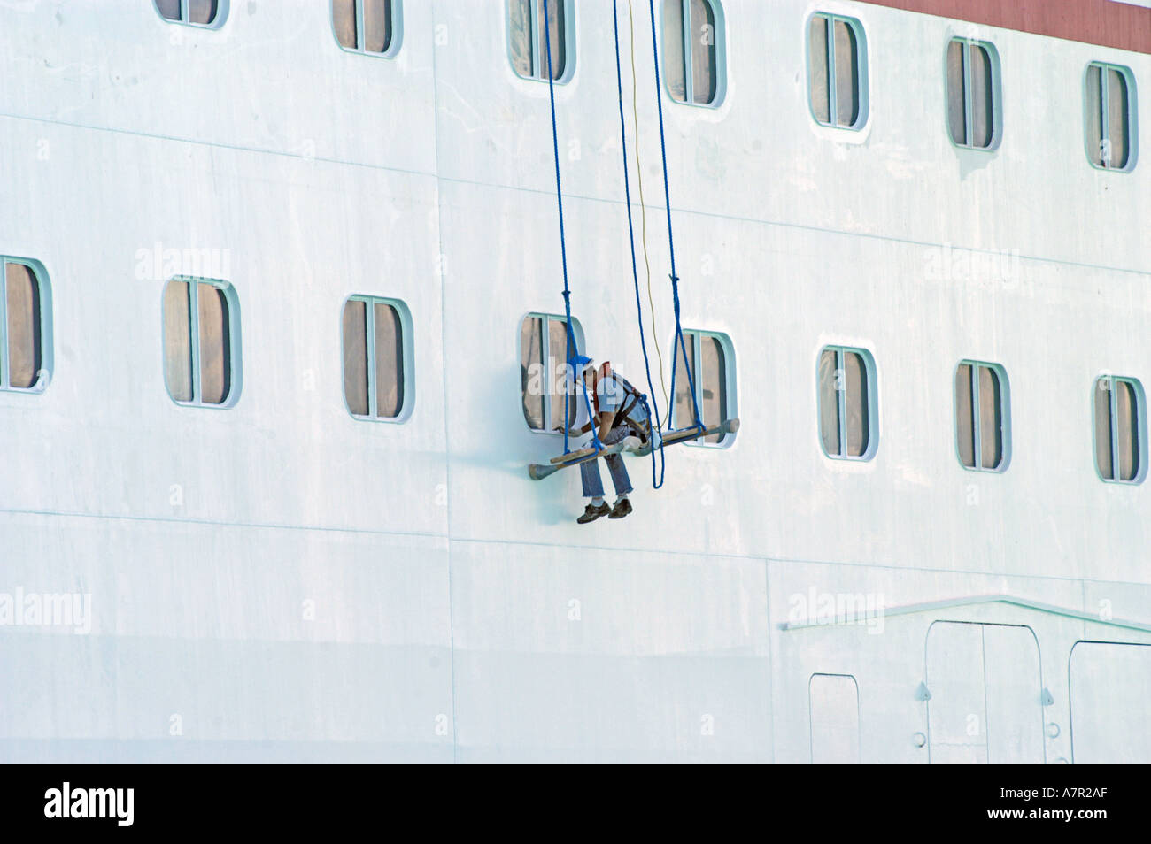 Man hanging from ropes while Painting a cruise ship in San Juan Puerto ...