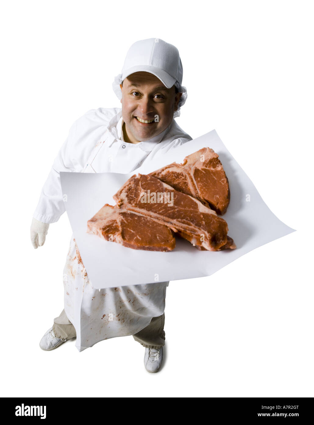 Butcher with steaks smiling Stock Photo - Alamy
