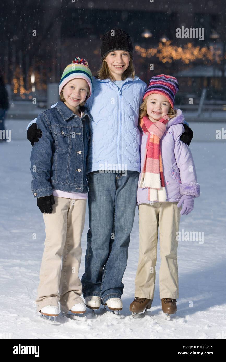Three girls with skates outdoors in winter smiling Stock Photo - Alamy