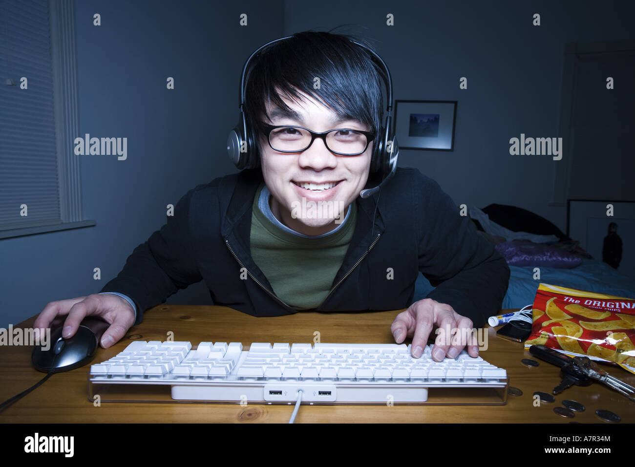 Man at keyboard with headset smiling Stock Photo - Alamy