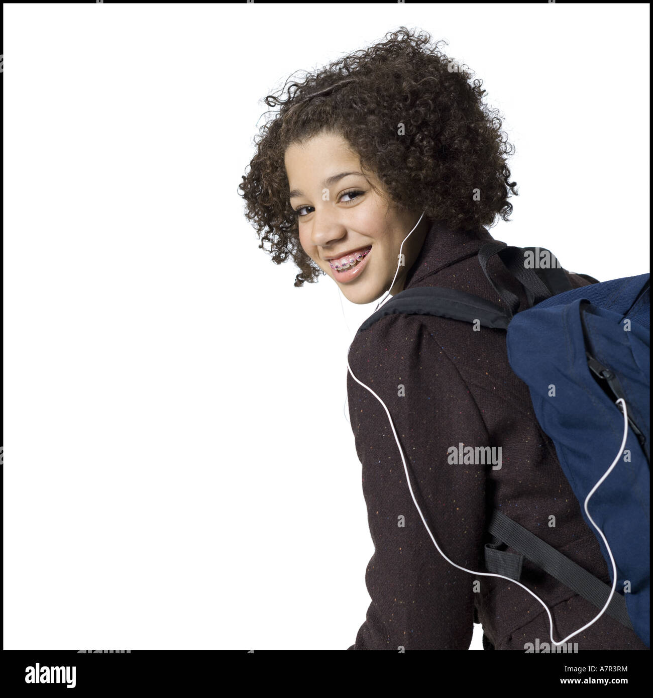 Girl with backpack and earbuds smiling with braces Stock Photo - Alamy