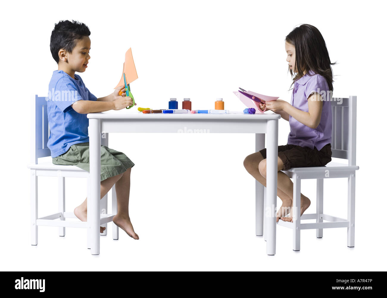 Boy and girl sitting at table doing crafts Stock Photo - Alamy