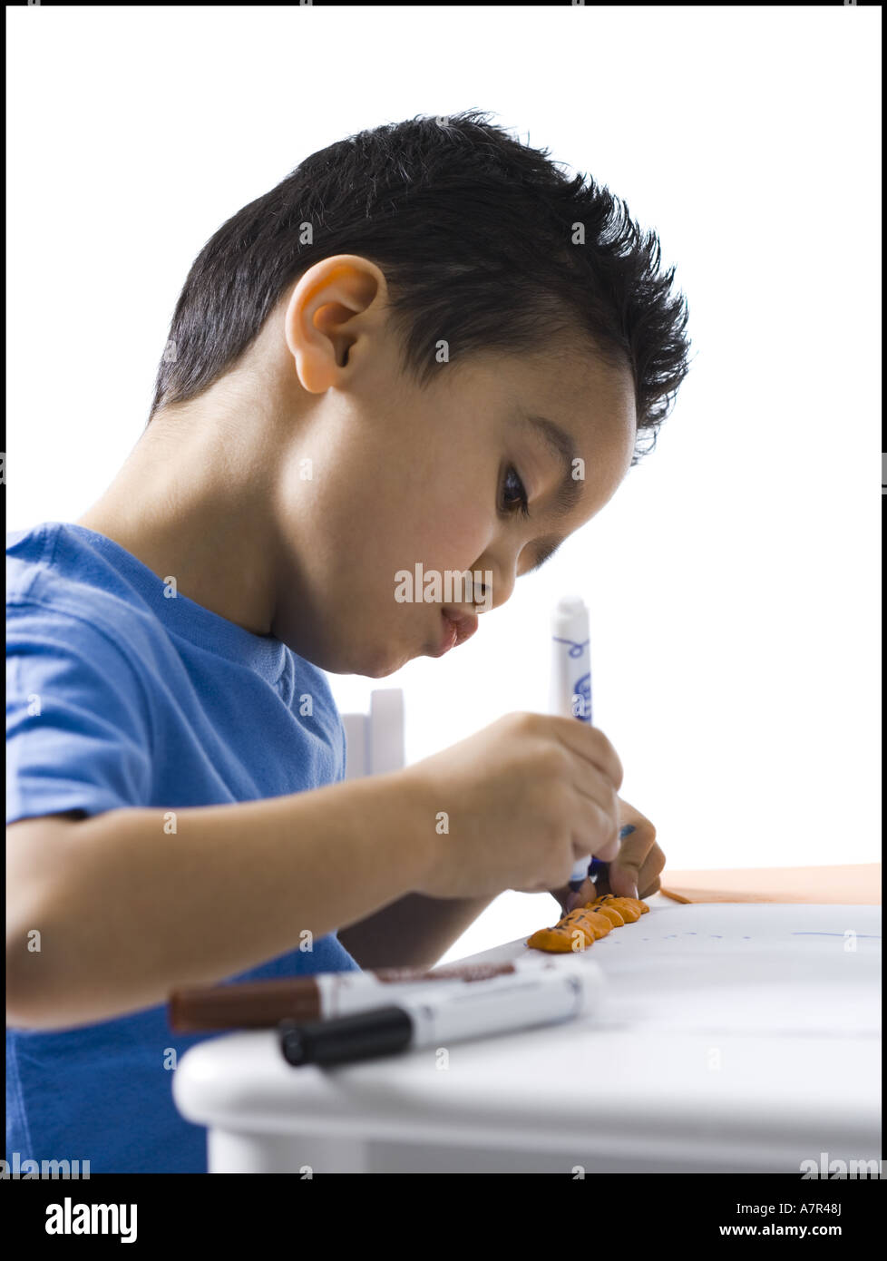 Boy sitting at table doing crafts Stock Photo - Alamy