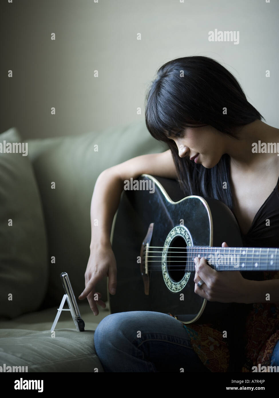 Woman tuning guitar with metronome Stock Photo - Alamy