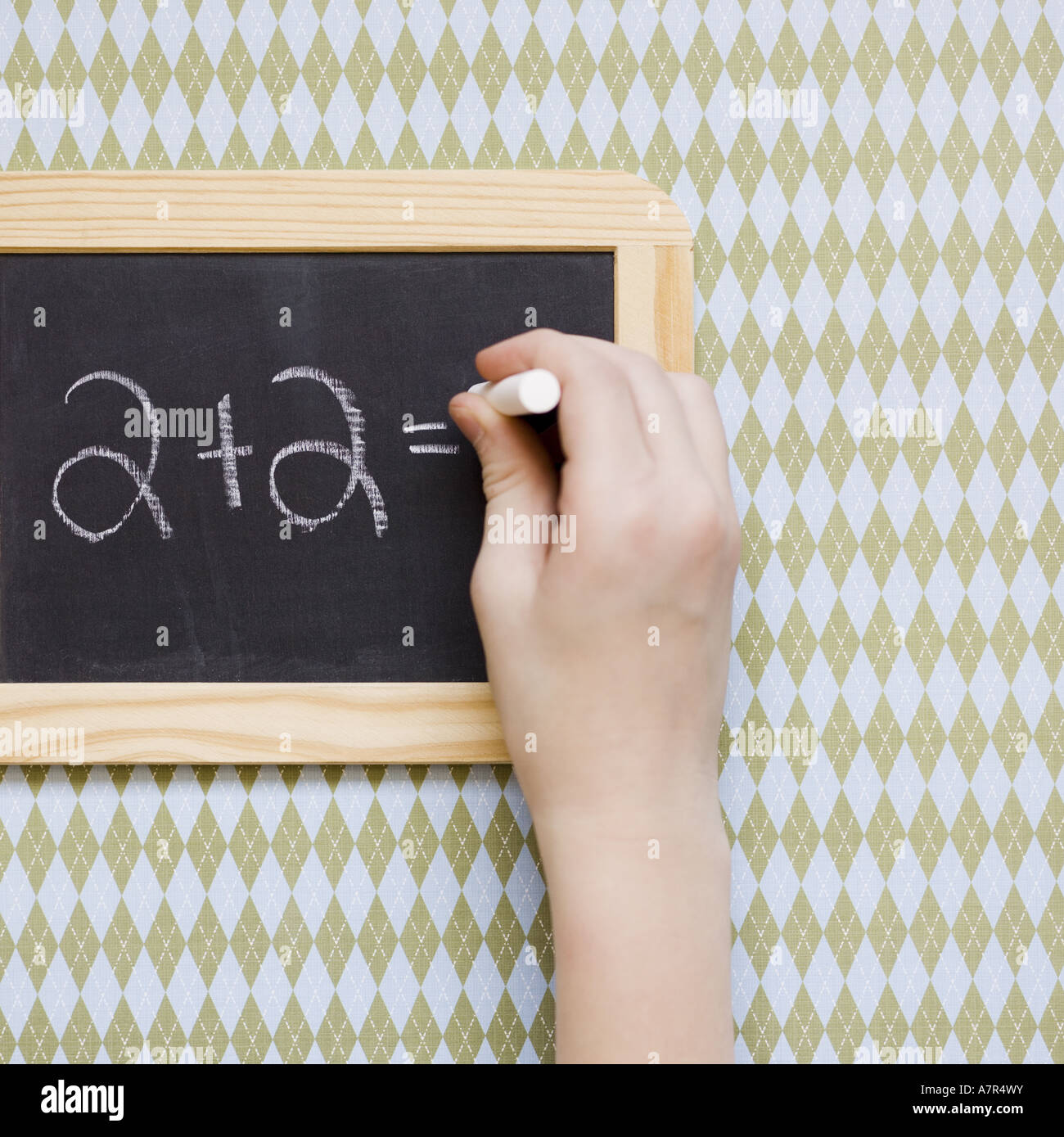 Person writing numbers on blackboard with chalk Stock Photo - Alamy
