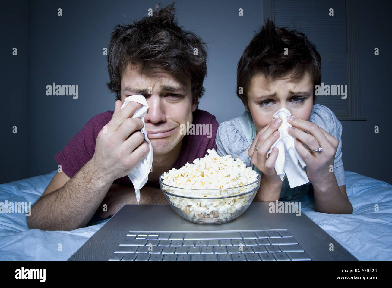 Couple crying with tissue and bowl of popcorn Stock Photo - Alamy
