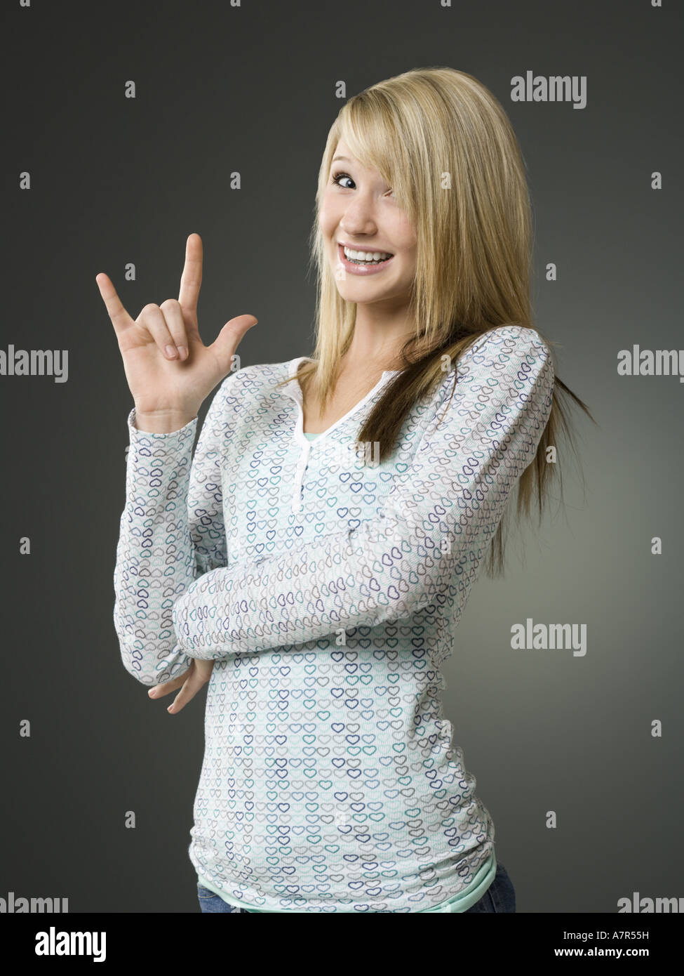 Girl making hand gesture and smiling Stock Photo - Alamy