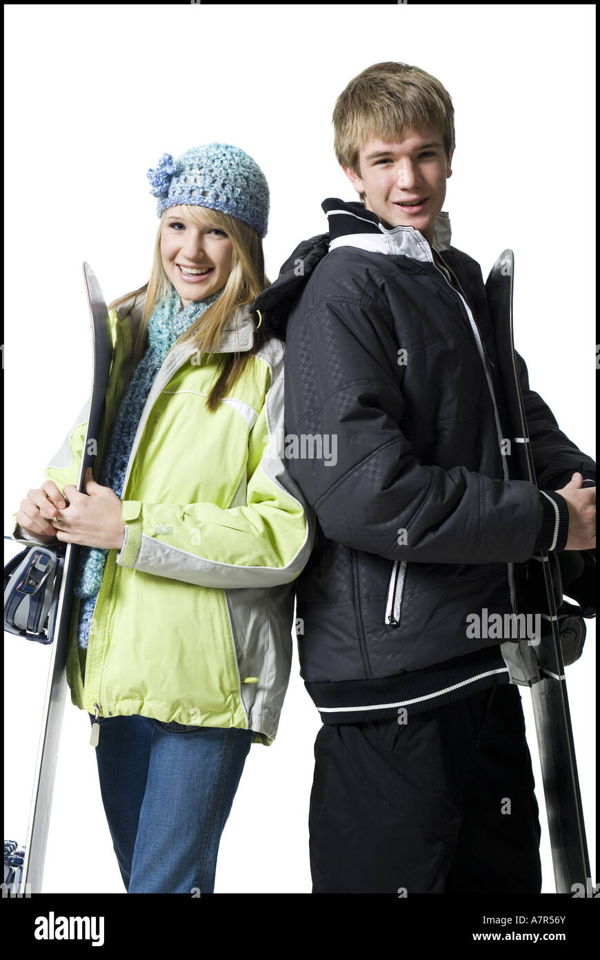 Teenage girl and boy with winter coats and skis smiling Stock Photo - Alamy