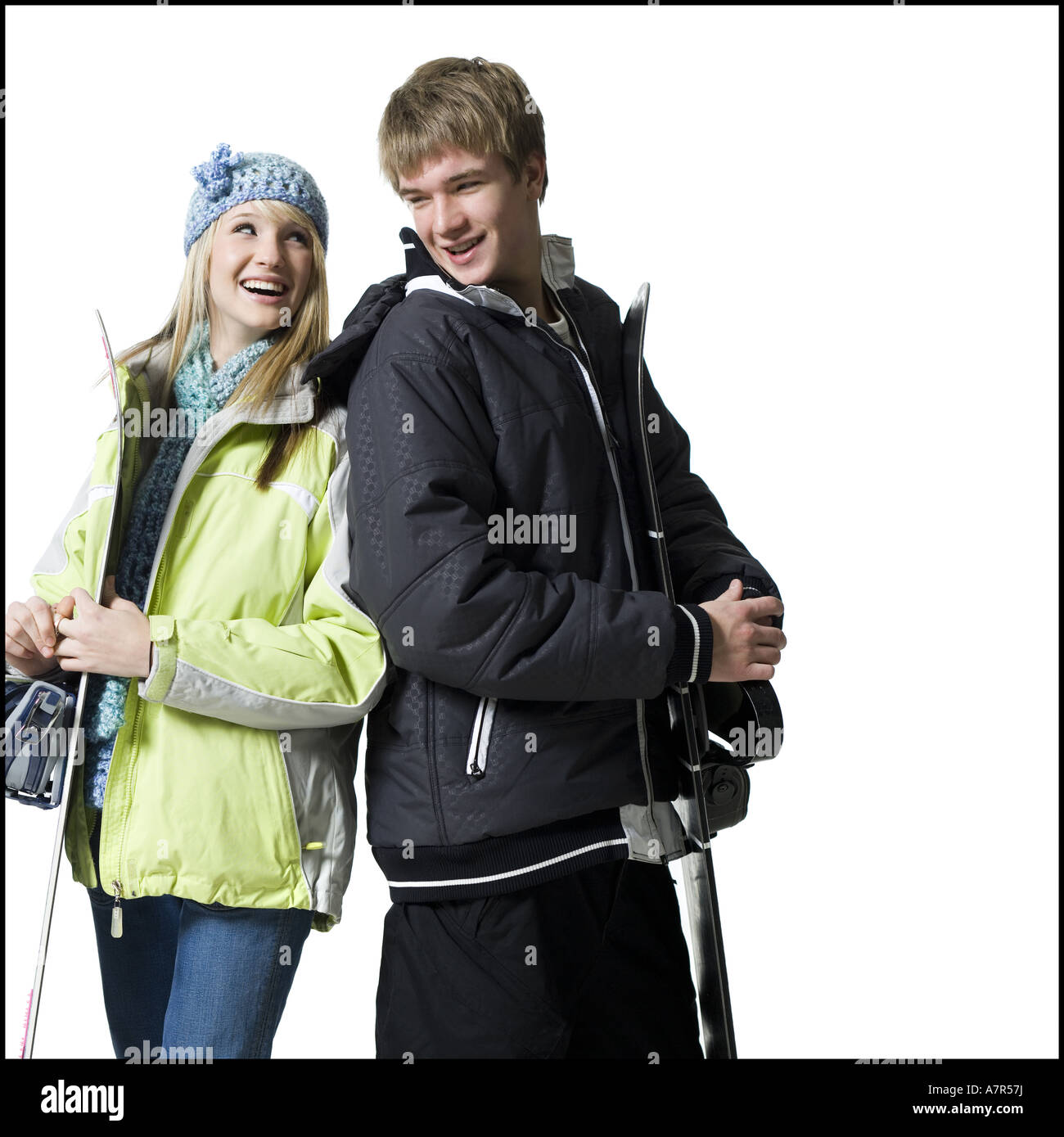 Teenage girl and boy with winter coats and skis smiling Stock Photo - Alamy