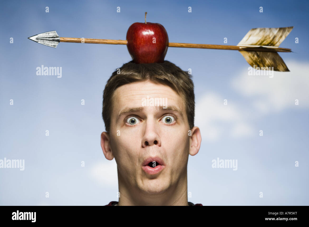 Man outdoors with arrow through red apple on head Stock Photo - Alamy