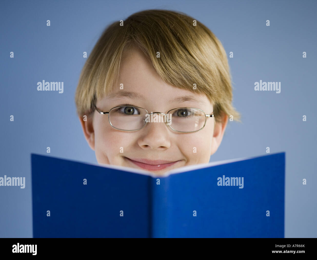 Boy reading book and smiling Stock Photo - Alamy