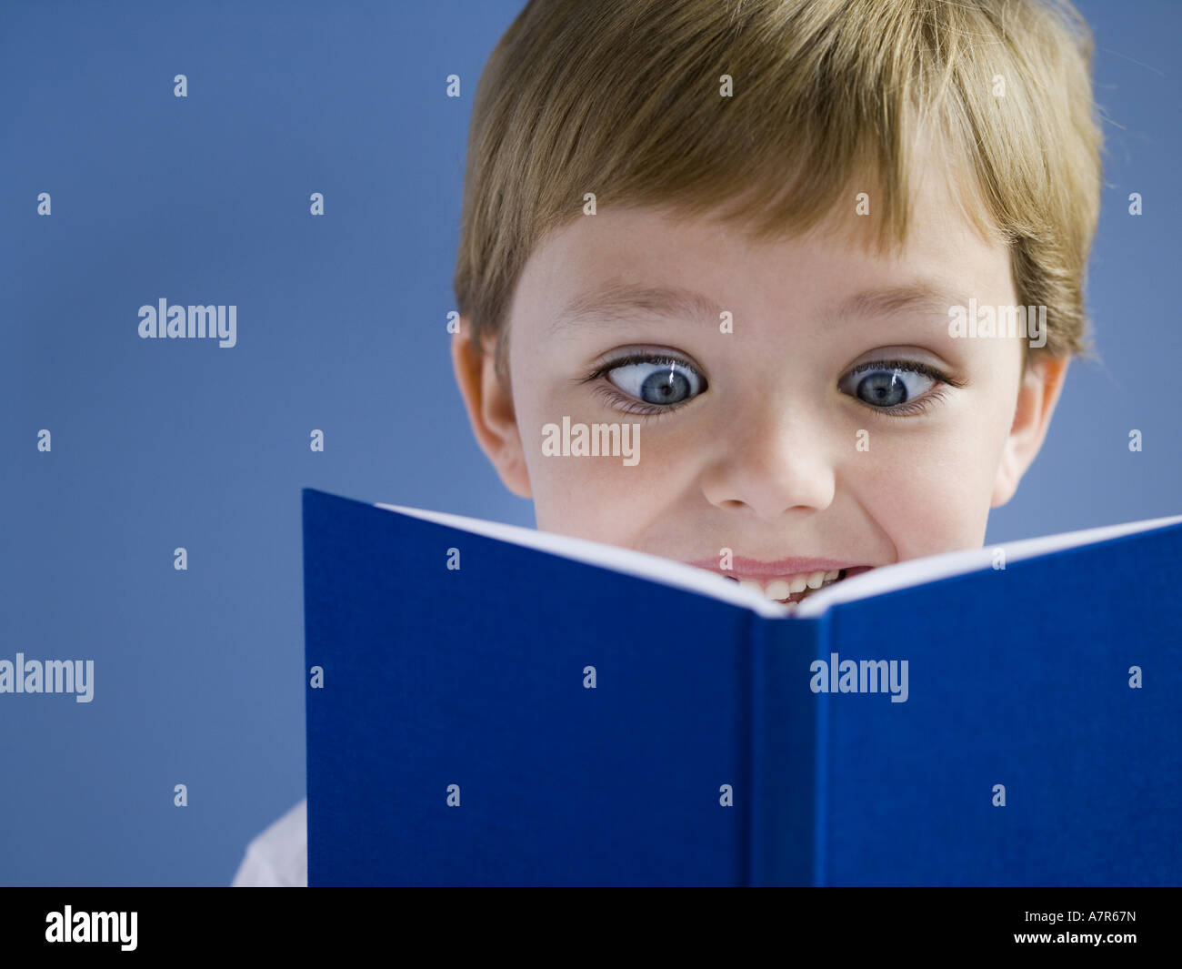 Boy reading book and smiling Stock Photo - Alamy