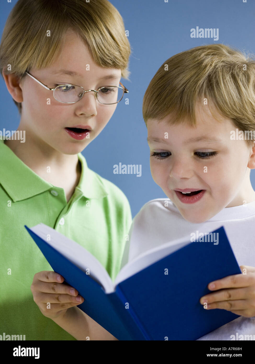 Two boys reading book Stock Photo - Alamy