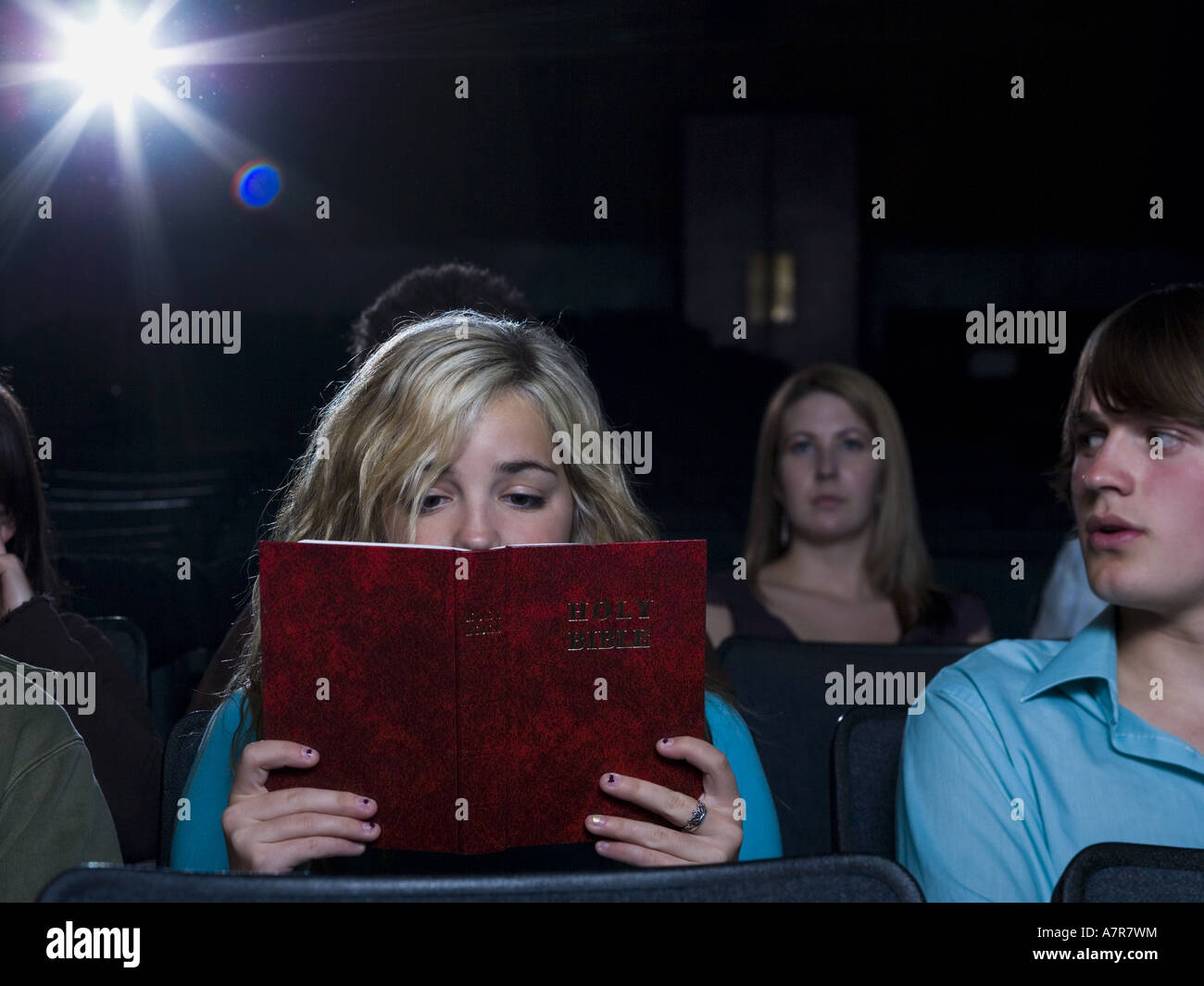 Girl reading hardcover book at movie theater Stock Photo - Alamy