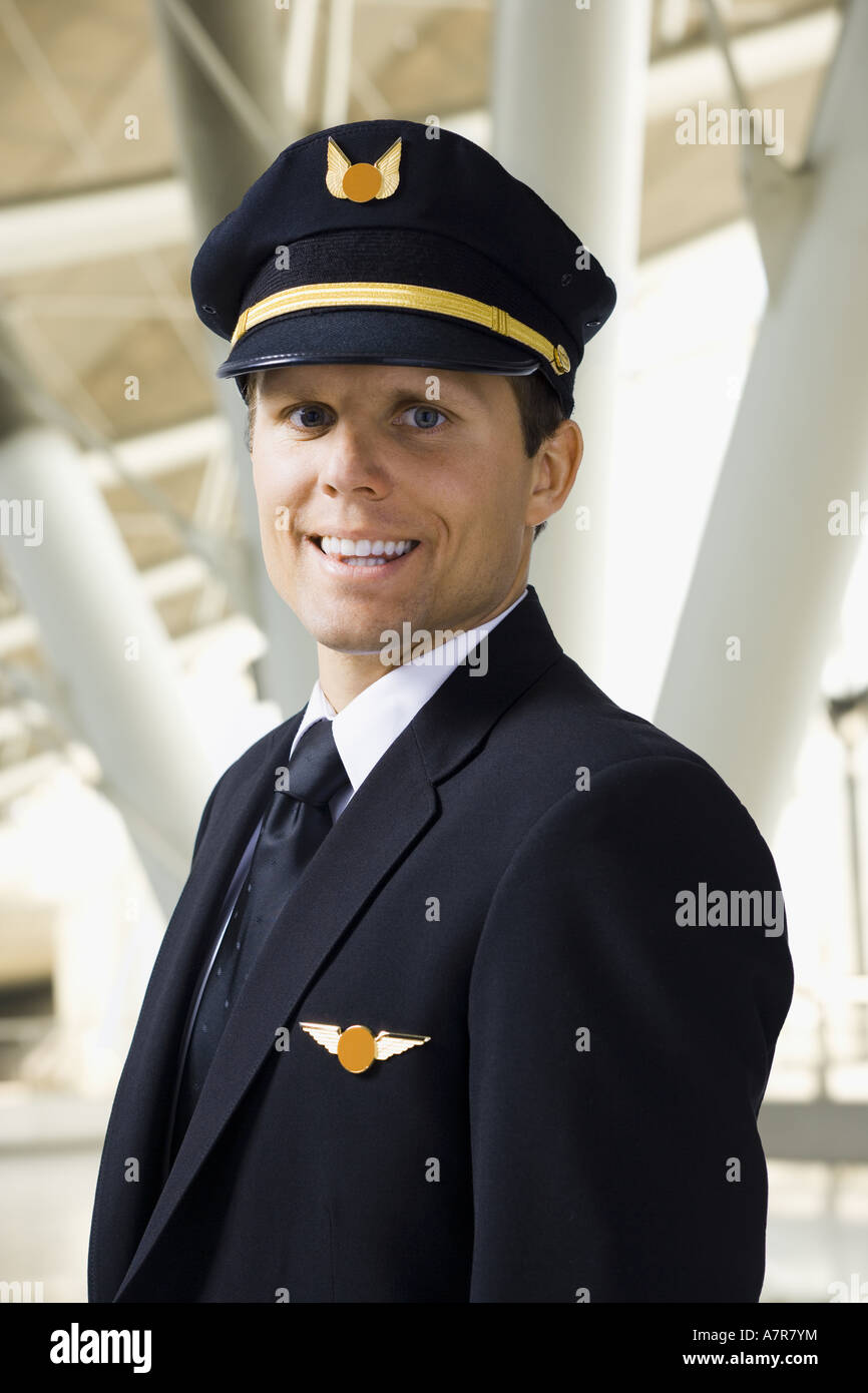 Pilot smiling in airport Stock Photo - Alamy