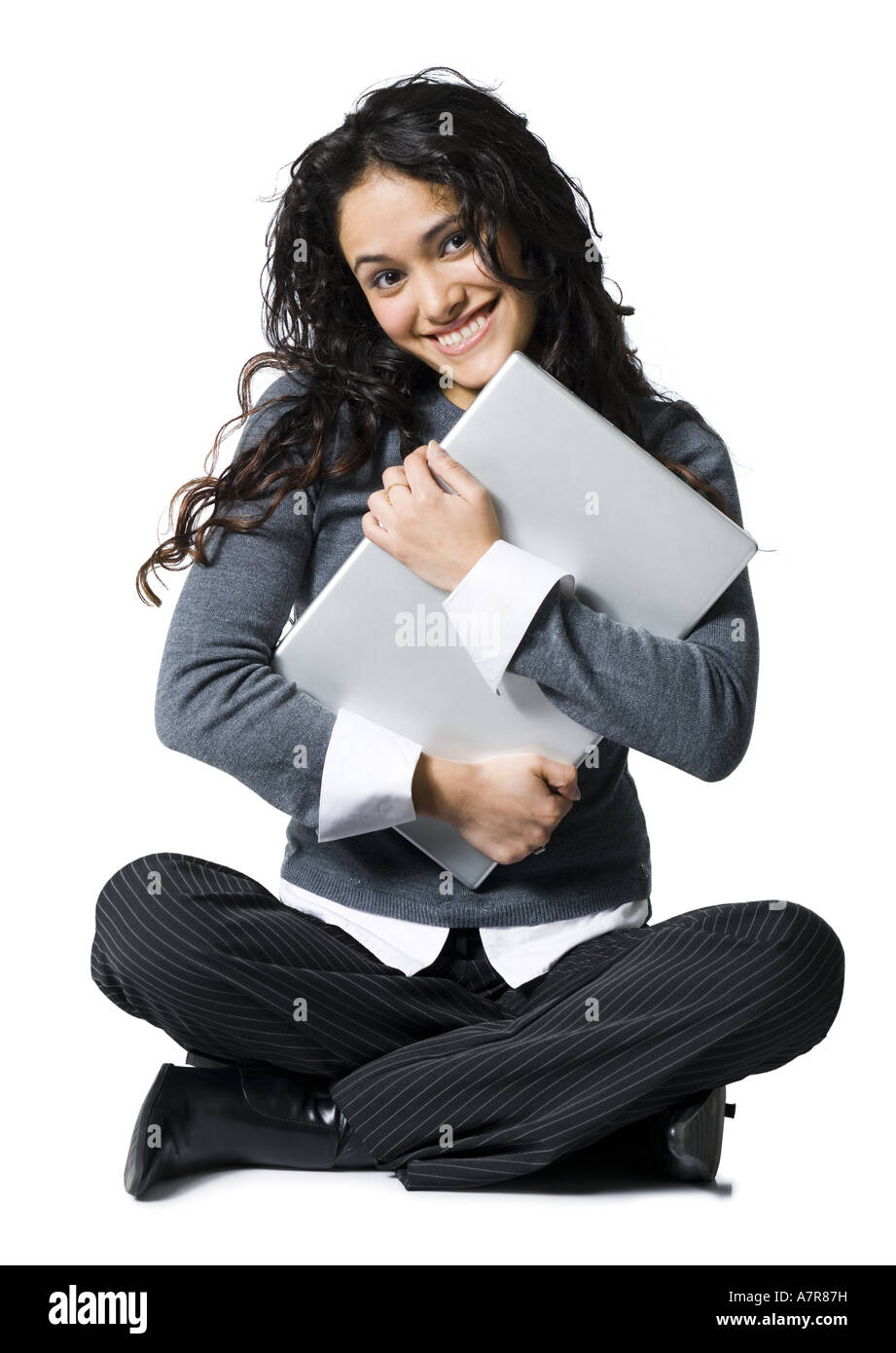 Woman sitting cross legged hugging laptop Stock Photo - Alamy