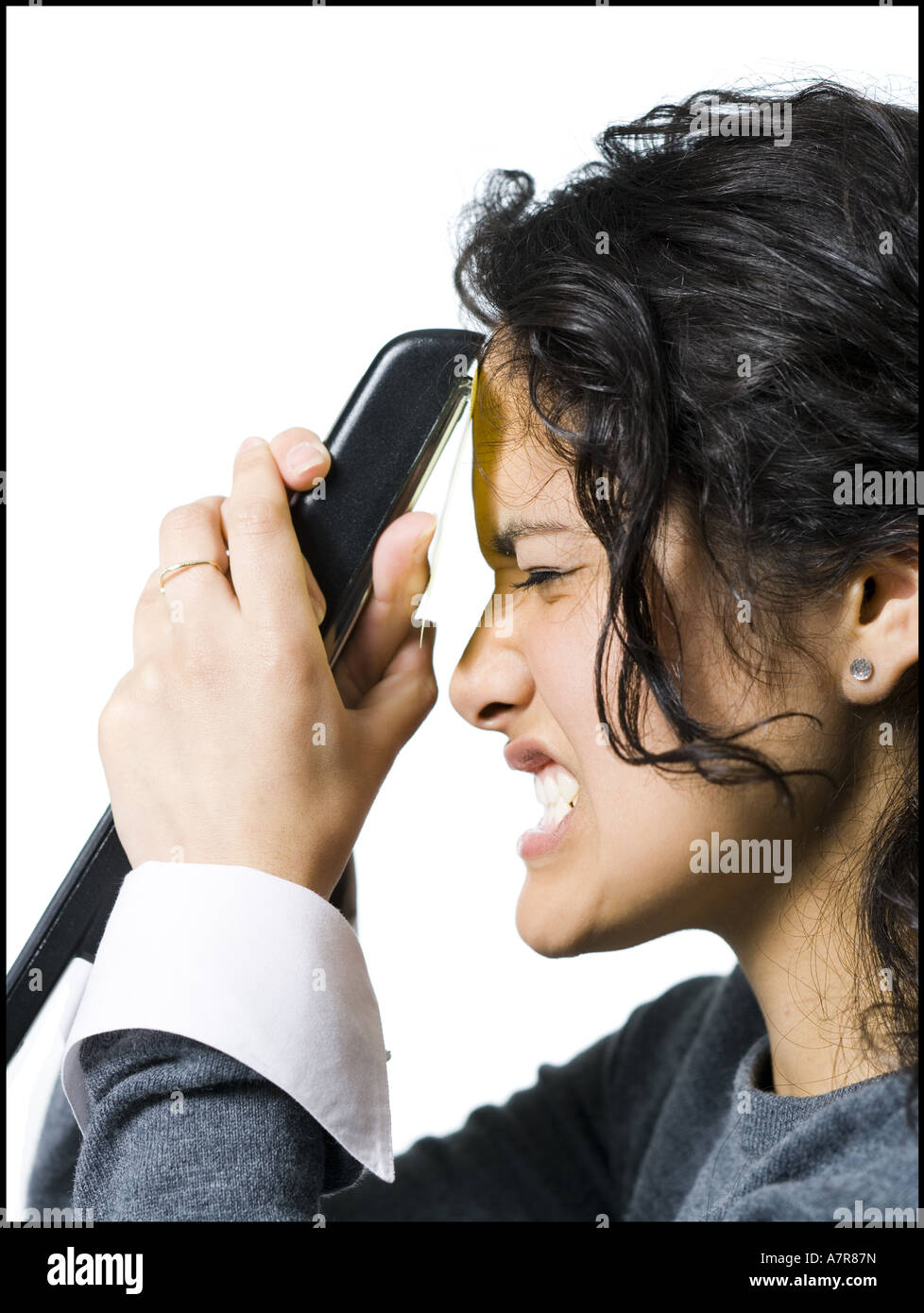 Profile of woman attaching sticky note to forehead with stapler Stock ...