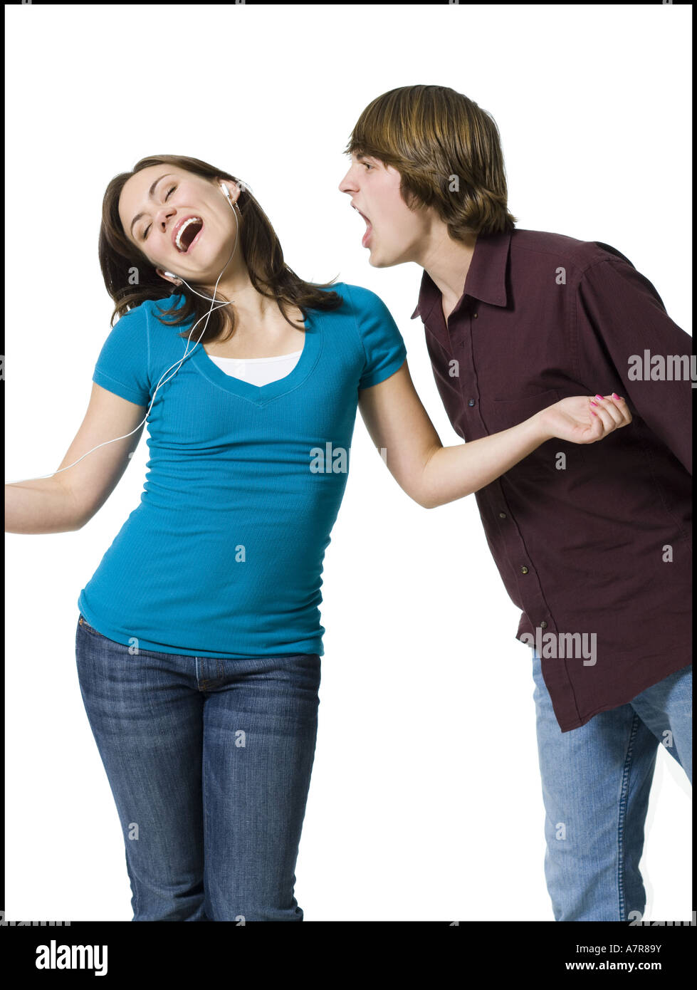 Girl listening to mp3 player with boy yelling Stock Photo - Alamy