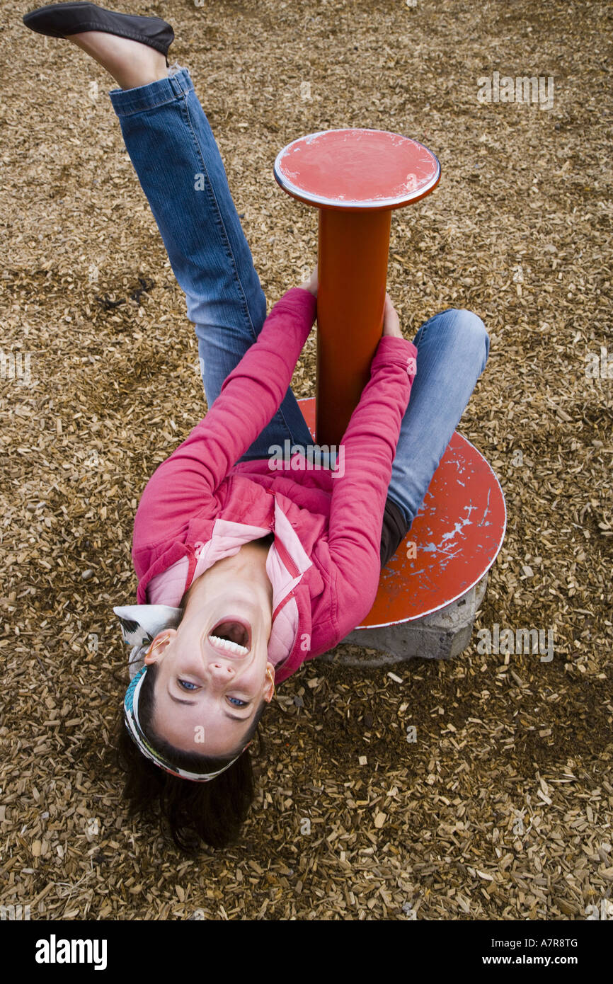 Girl playing on roundabout outdoors Stock Photo - Alamy