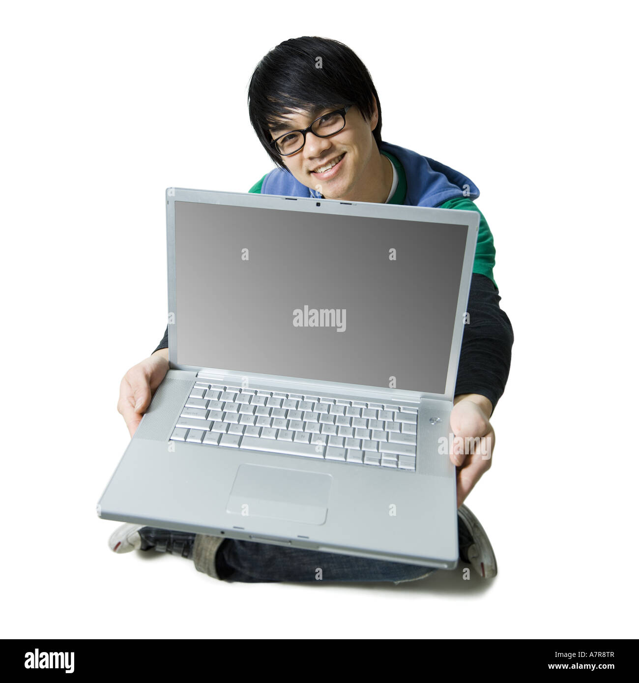 Man with laptop sitting cross legged smiling Stock Photo - Alamy
