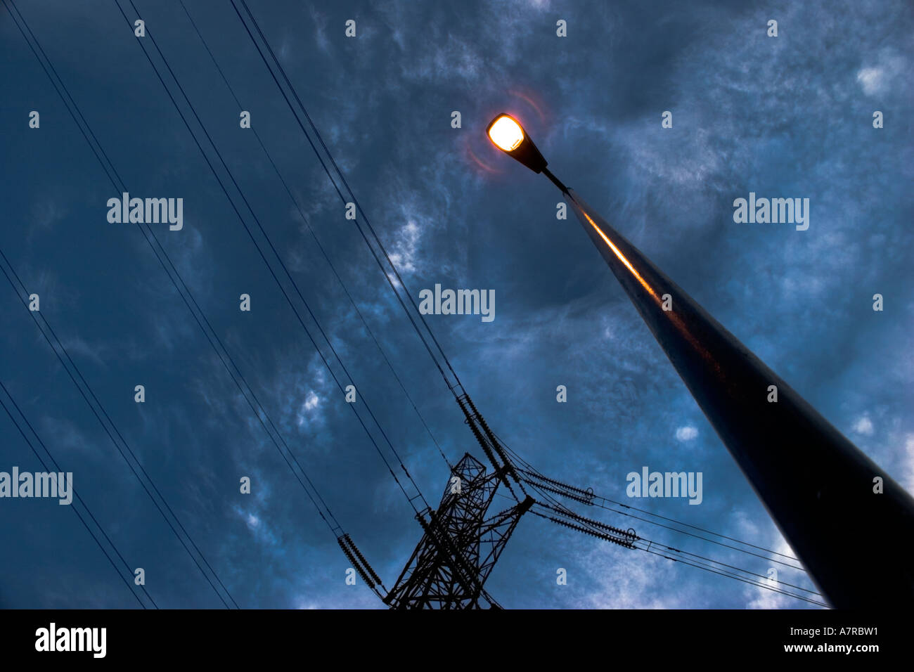electricity pylon at dusk with illuminated street lamp Stock Photo - Alamy