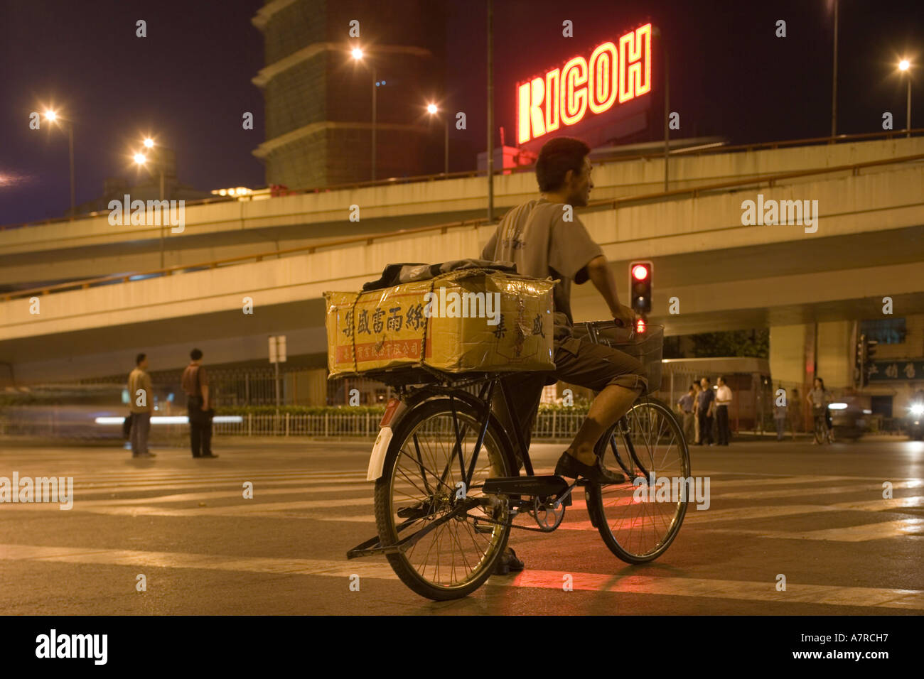 Asia China Shanghai Young Chinese woman on bicycle waits for light to ...